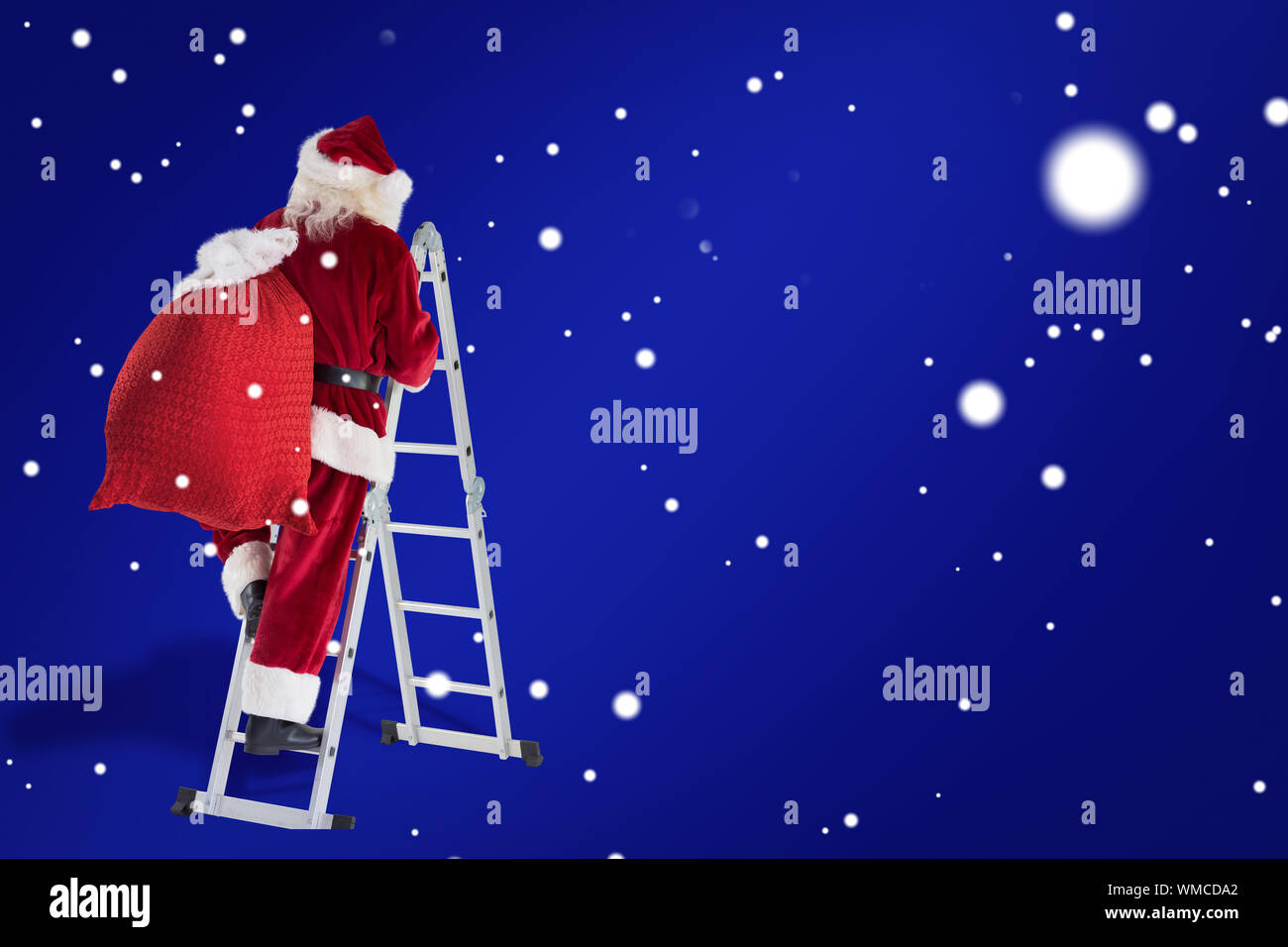 Santa steps up a ladder against blue Stock Photo - Alamy