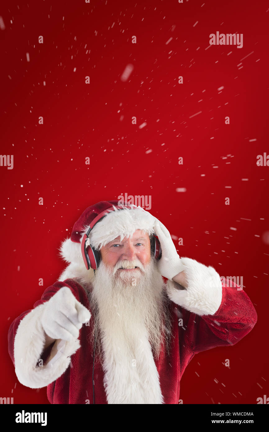Santa is listening some music against red background Stock Photo - Alamy