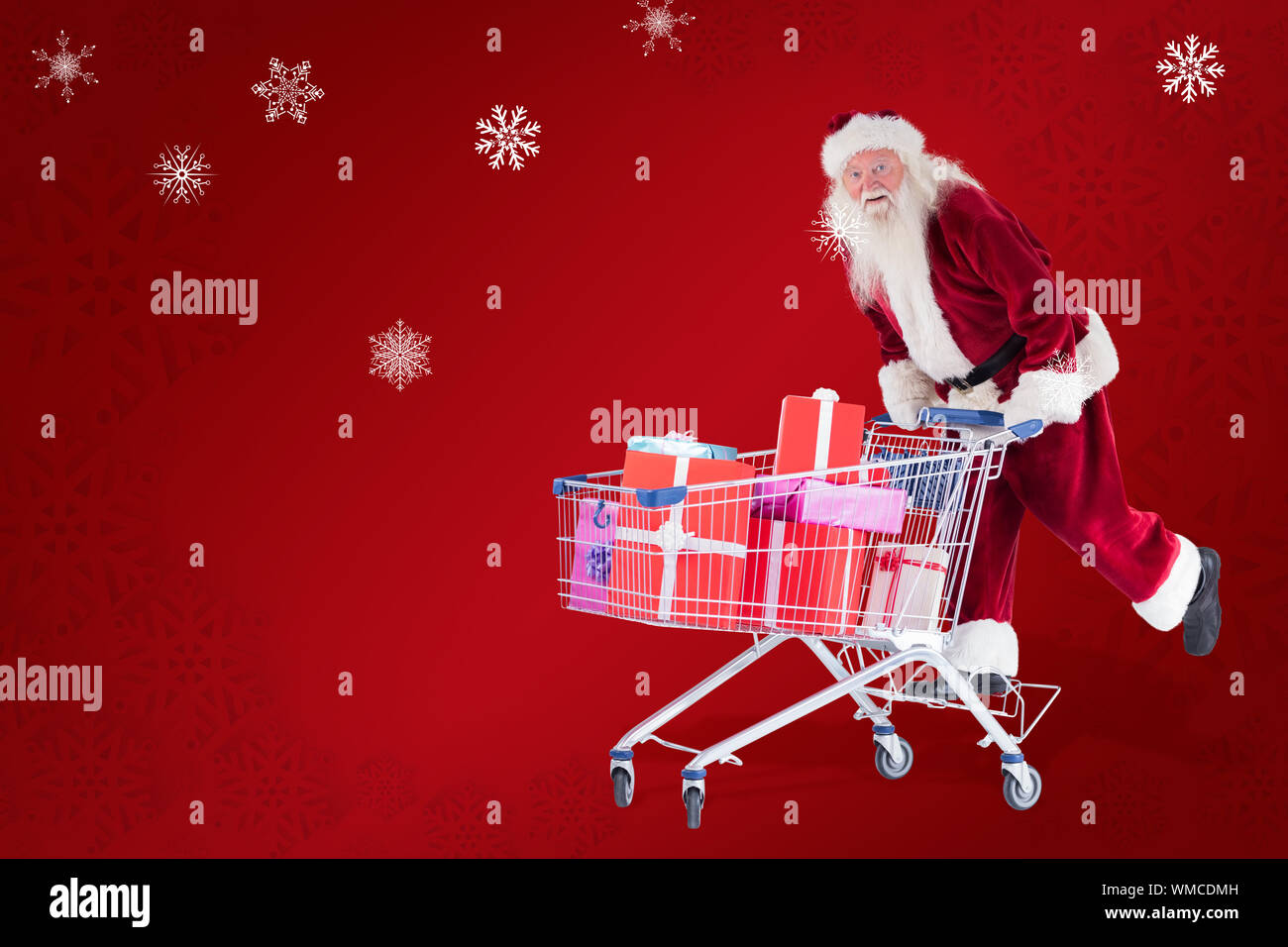 Santa rides on a shopping cart against red snowflake background Stock ...