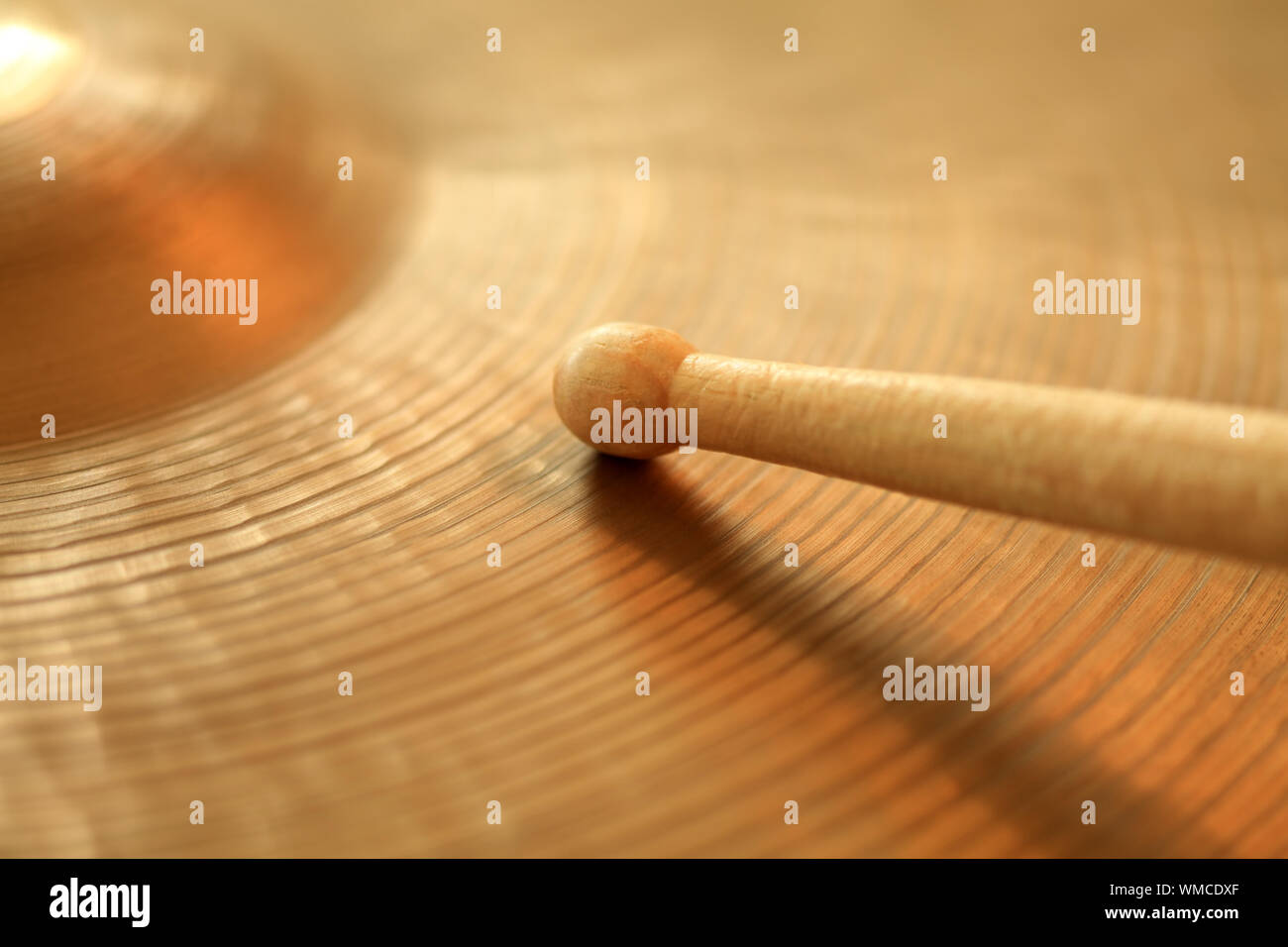 Photo of a drumstick playing on a hi-hat or ride cymbal. Focus on tip ...