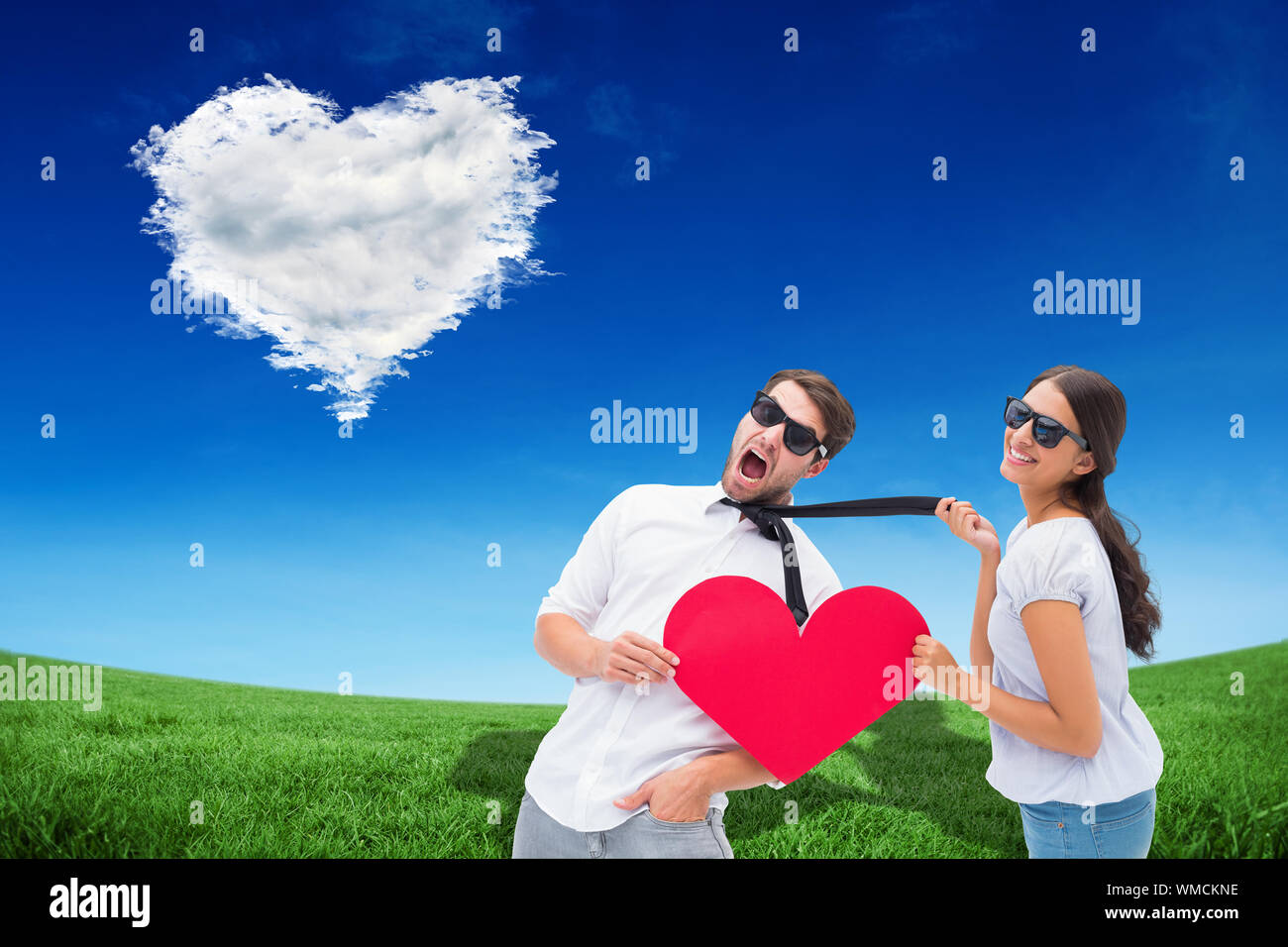 Brunette pulling her boyfriend by the tie holding heart against cloud ...