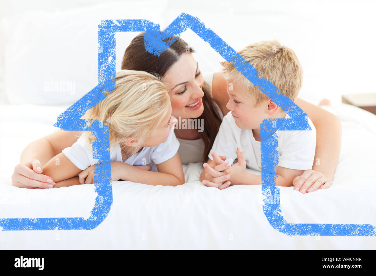 Merry children and their mom discussing lying on a bed against house ...