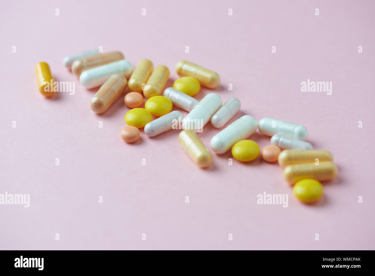 Vitamins and supplements on pink paper background. Concept for a ...