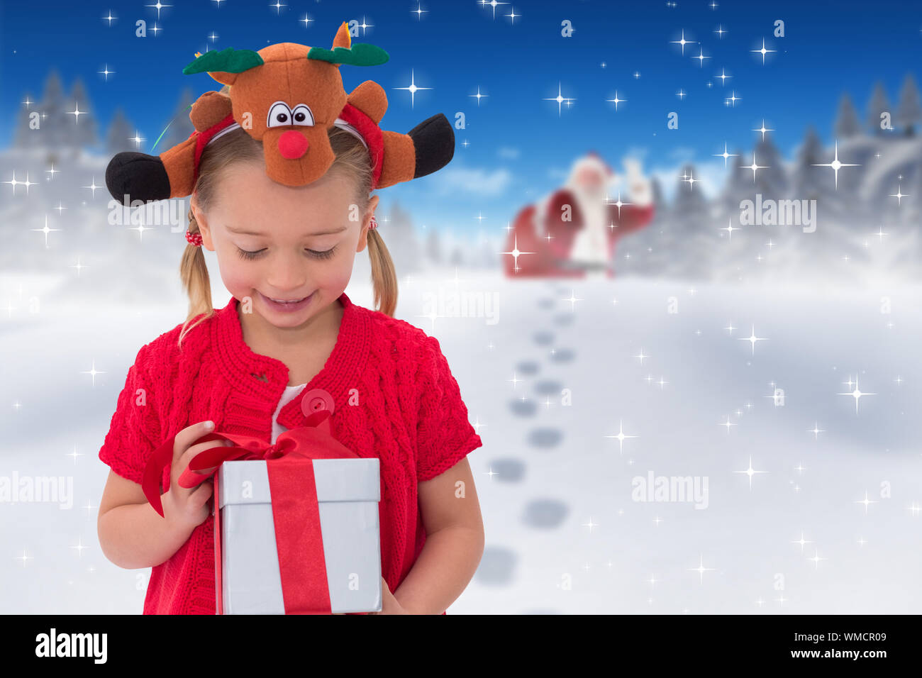 Cute little girl wearing rudolph headband against bright blue sky over ...