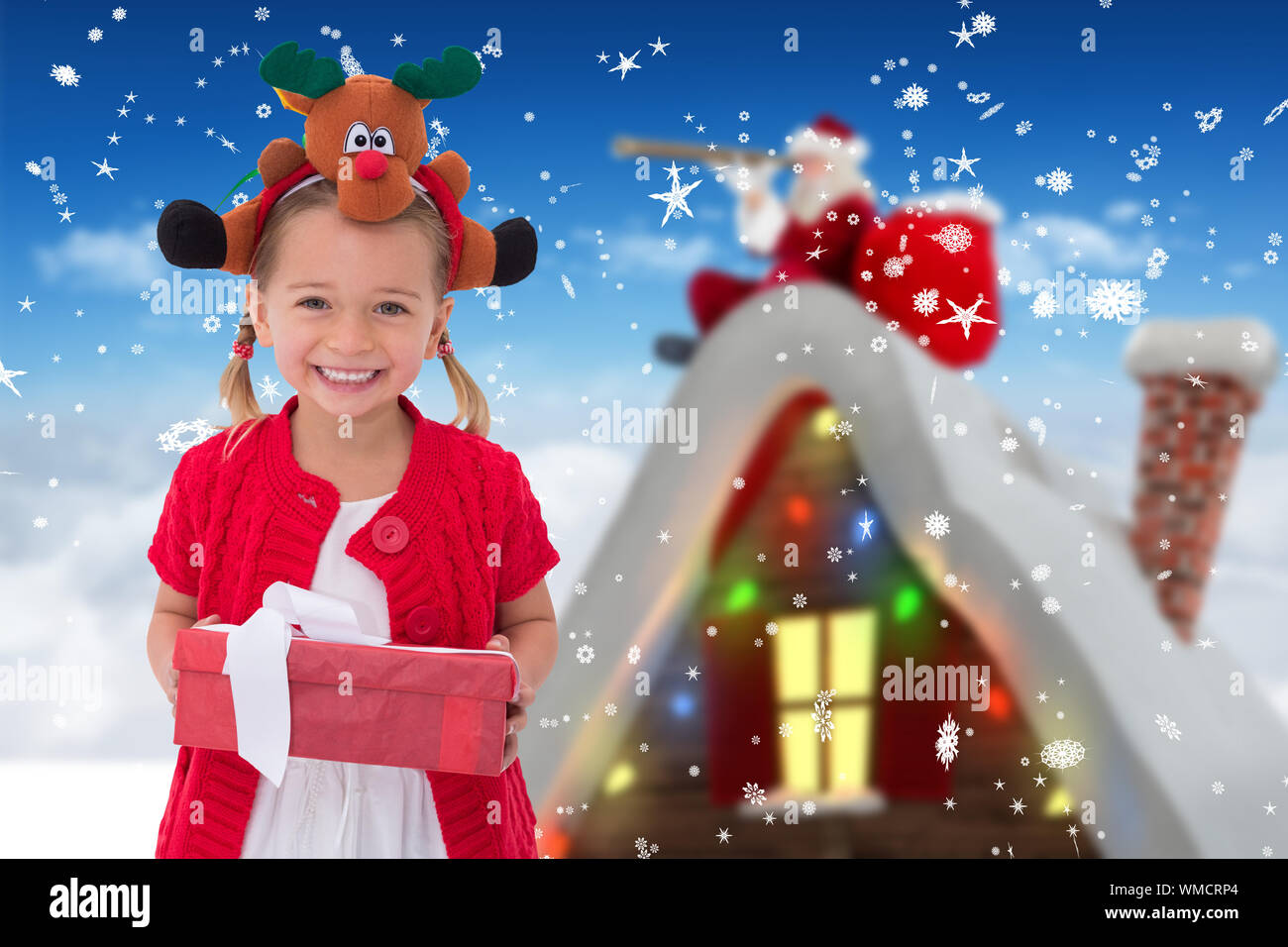 Cute little girl wearing rudolph headband against bright blue sky over ...