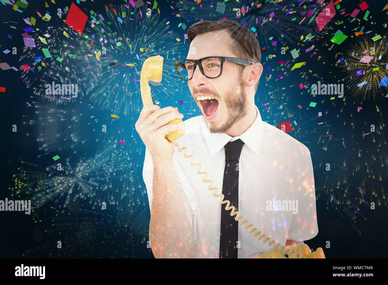 Geeky businessman shouting at telephone against colourful fireworks ...