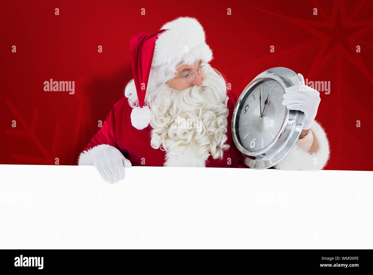 Santa holding a clock and sign against red snowflake background Stock ...