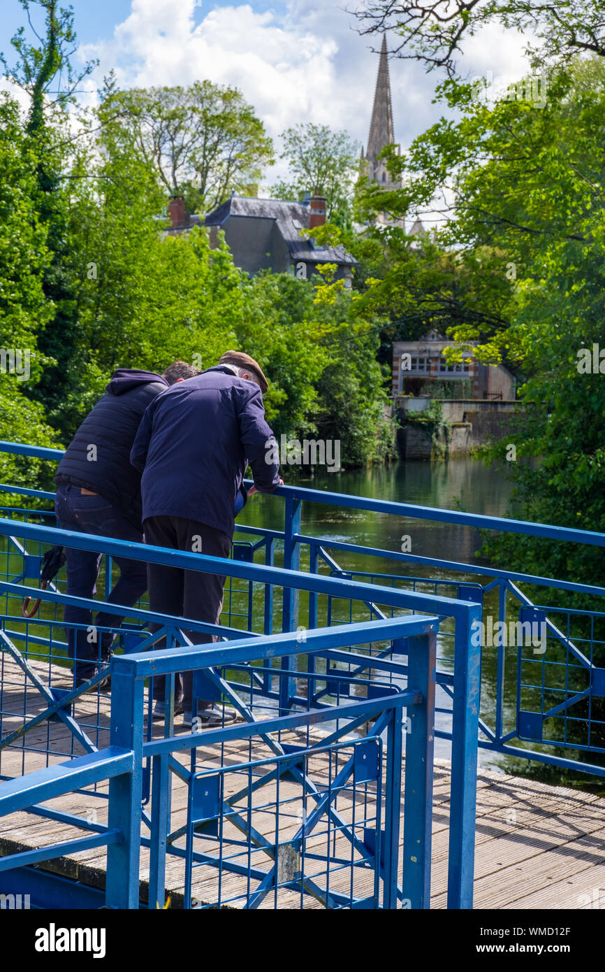 Niort, France - May 11, 2019: Elderly man on a foot bridge over a ...