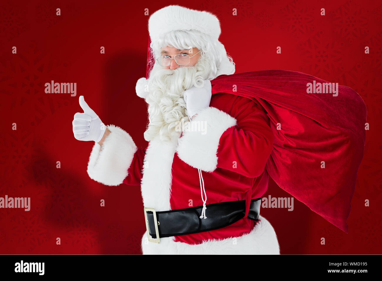 Positive santa with his sack and thumbs up against red snowflake ...