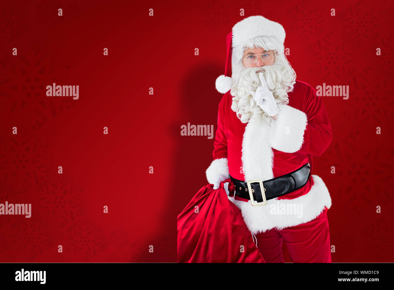 Santa holding his sack and keeping a secret against red snowflake ...