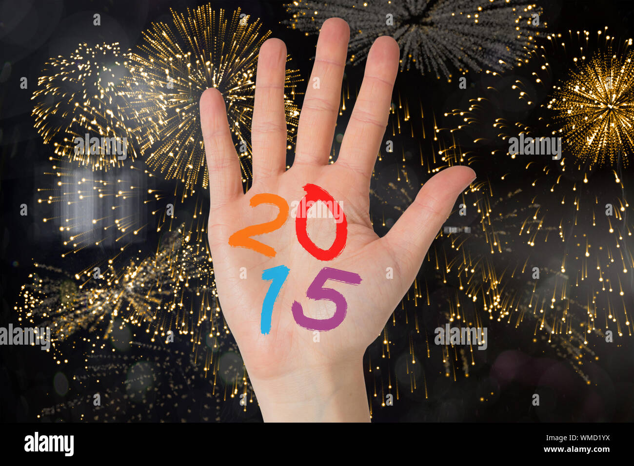 Hand with fingers spread out against colourful fireworks exploding on ...