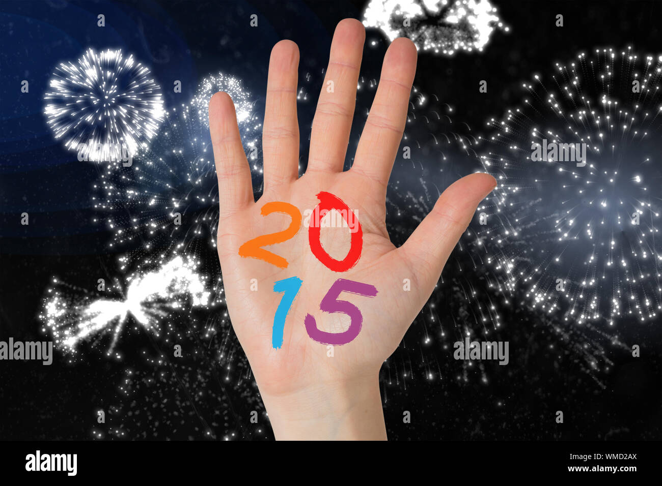 Hand with fingers spread out against white fireworks exploding on black ...