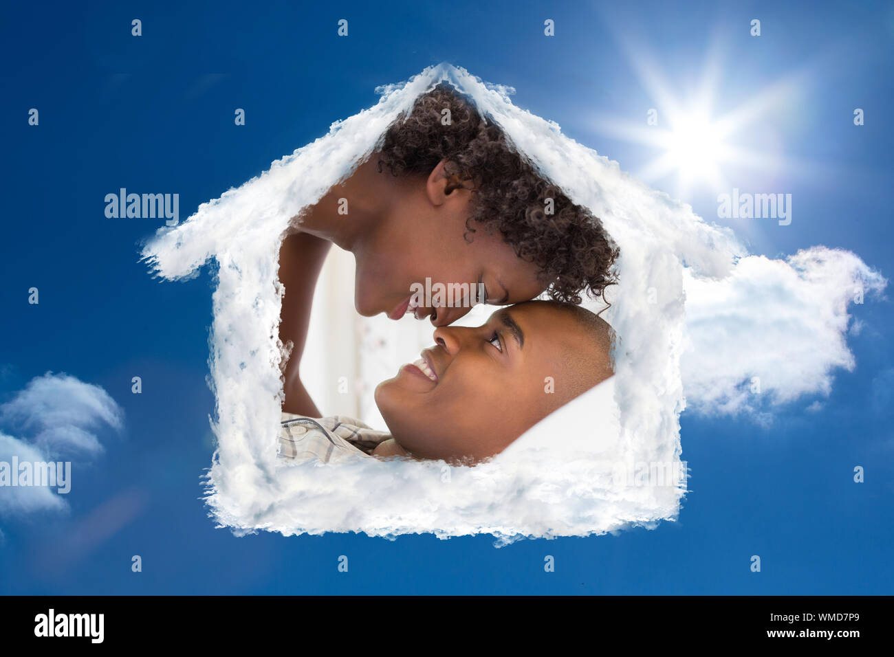 Intimate couple messing about in the morning on bed against bright blue ...