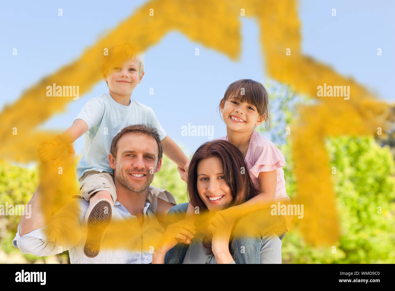 Parents giving children a piggyback against house outline in clouds ...