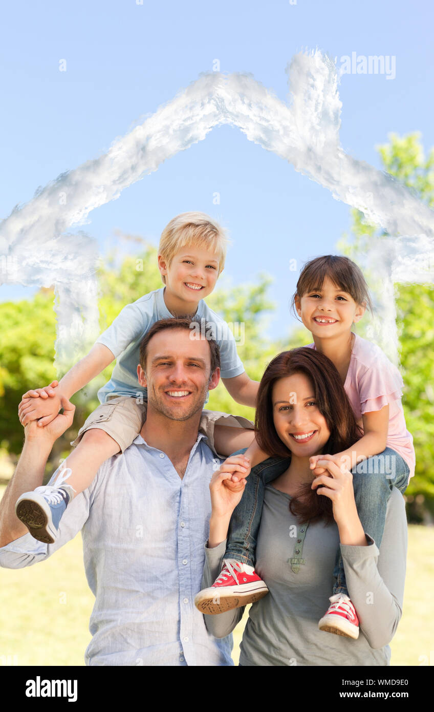Parents giving children a piggyback against house outline in clouds ...
