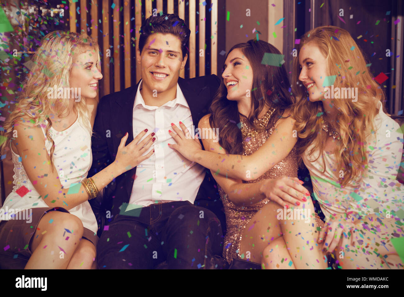 Happy friends smiling at camera against flying colours Stock Photo - Alamy