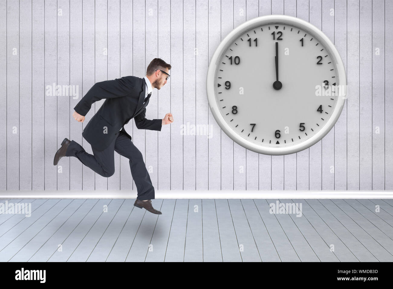 Geeky young businessman running mid air against grey room Stock Photo ...
