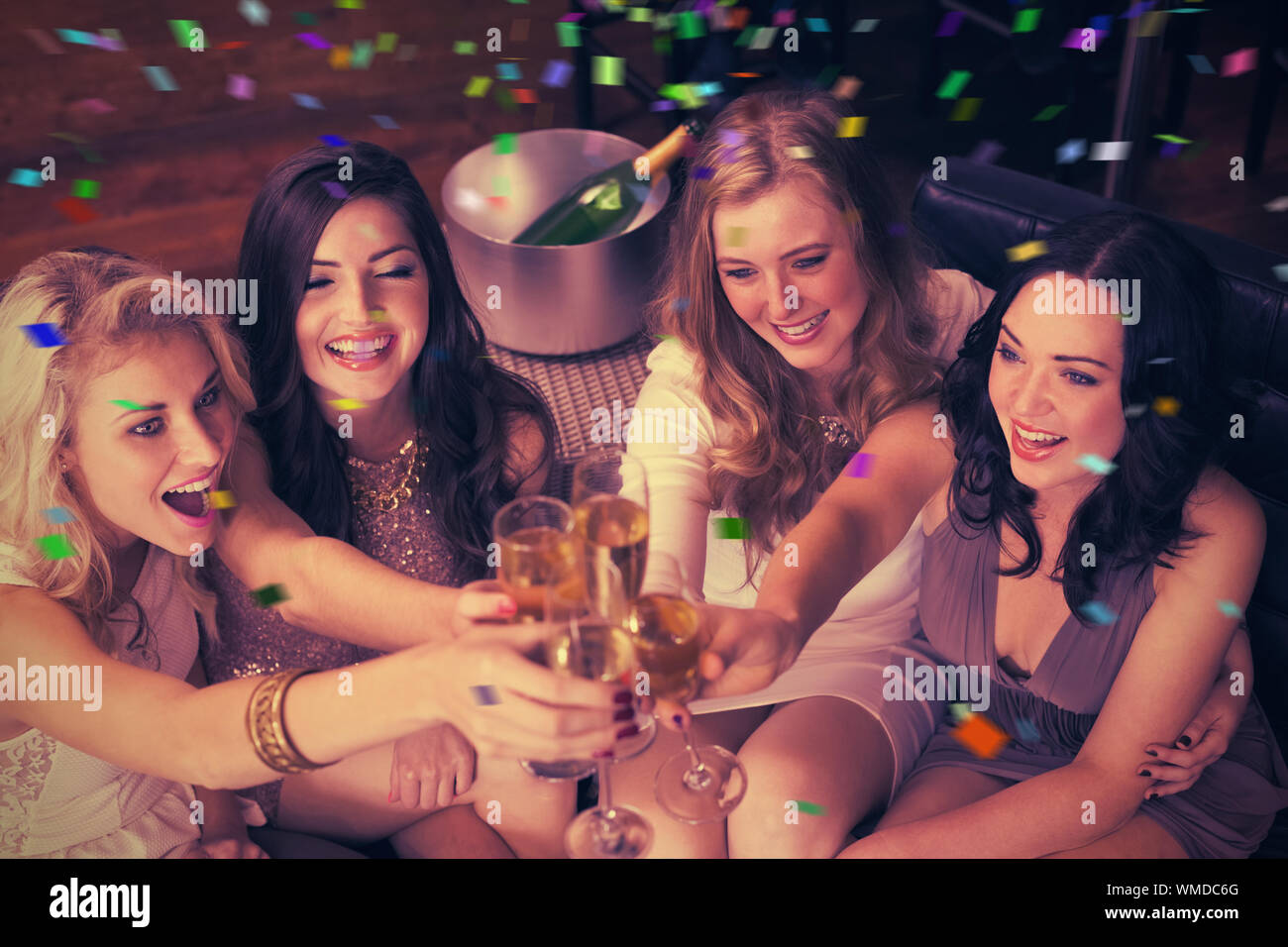 Pretty friends having a drink together against flying colours Stock ...