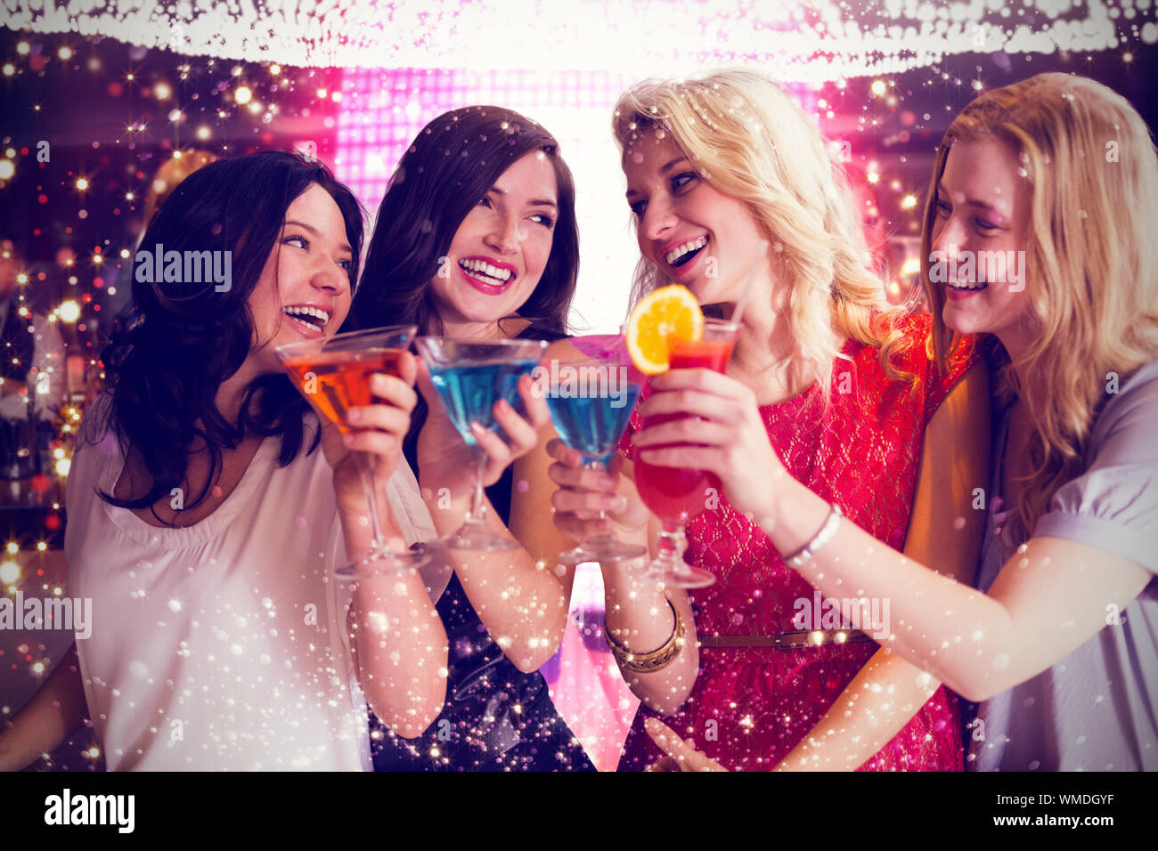 Friends with drinks against gold and red lights Stock Photo - Alamy