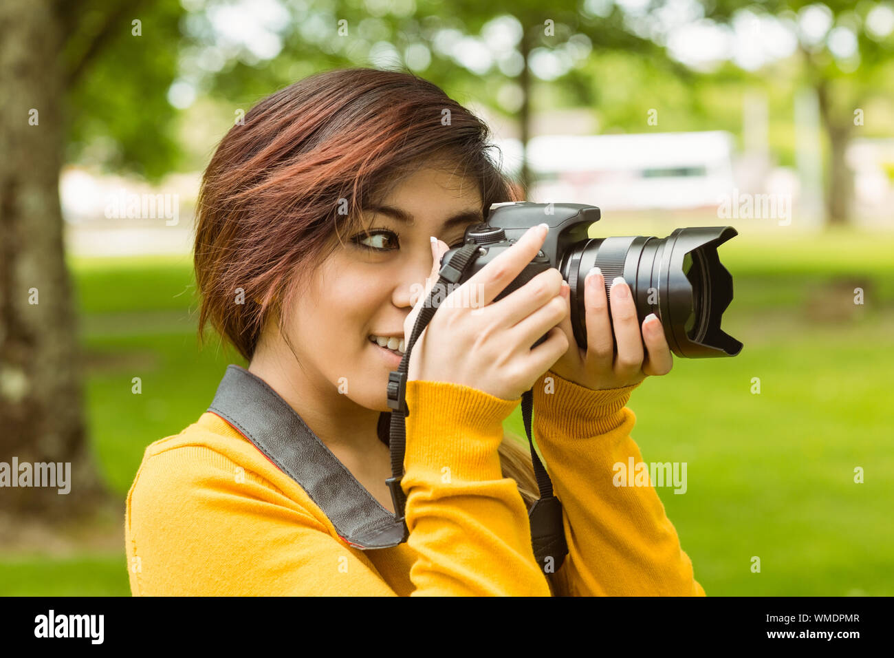 Side view of beautiful female photographer at the park Stock Photo - Alamy