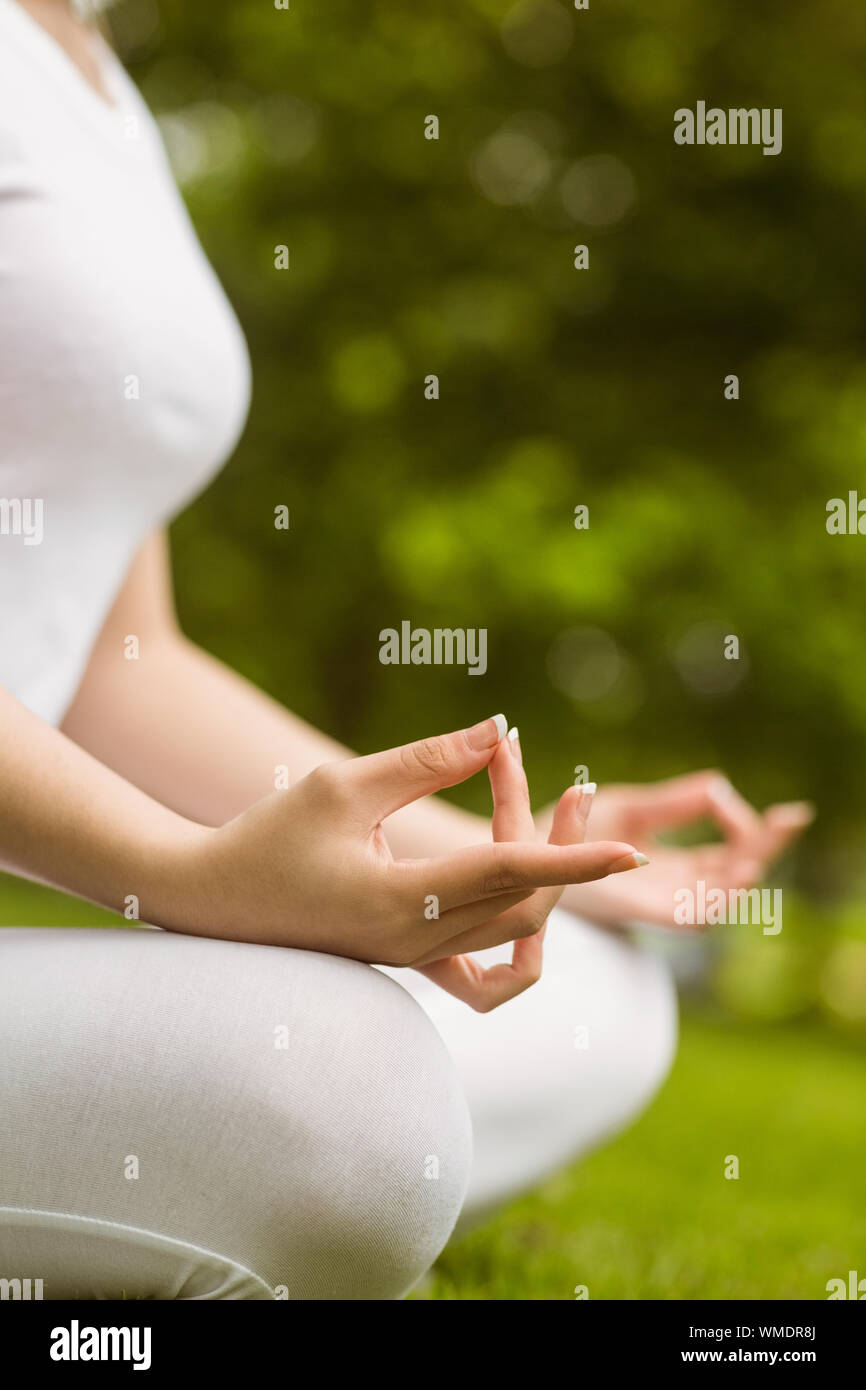 Side view mid section of healthy young woman sitting in lotus pose at ...
