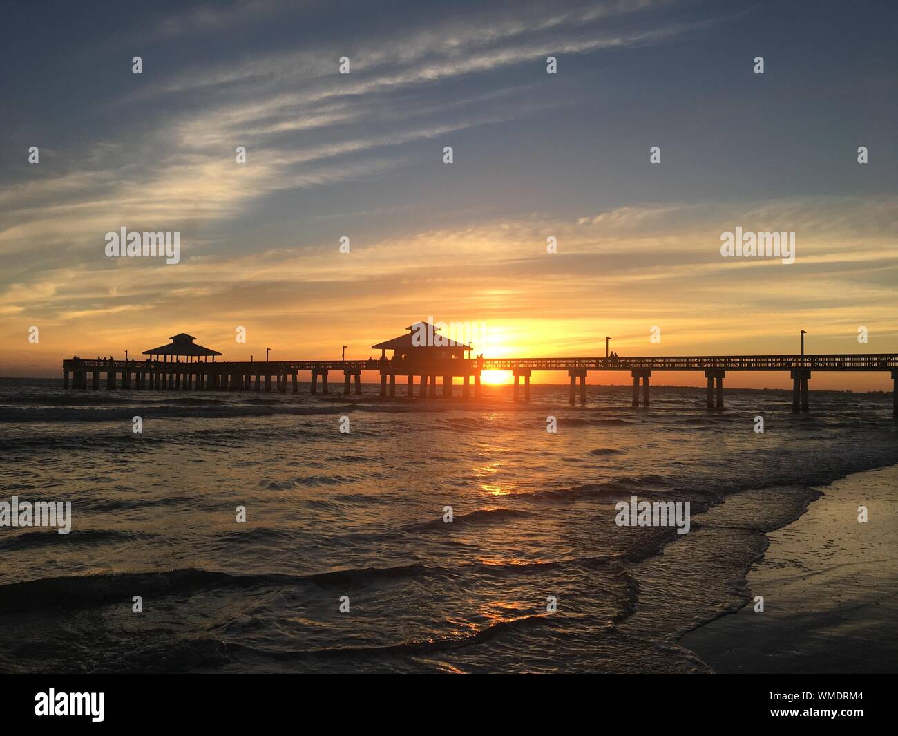 Pier on beach at sunset hi-res stock photography and images - Alamy