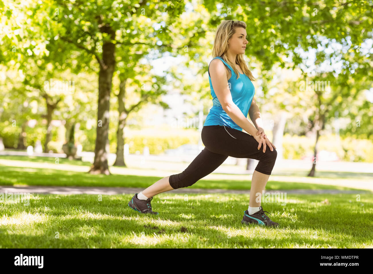 Fit blonde stretching on grass hi-res stock photography and images - Alamy