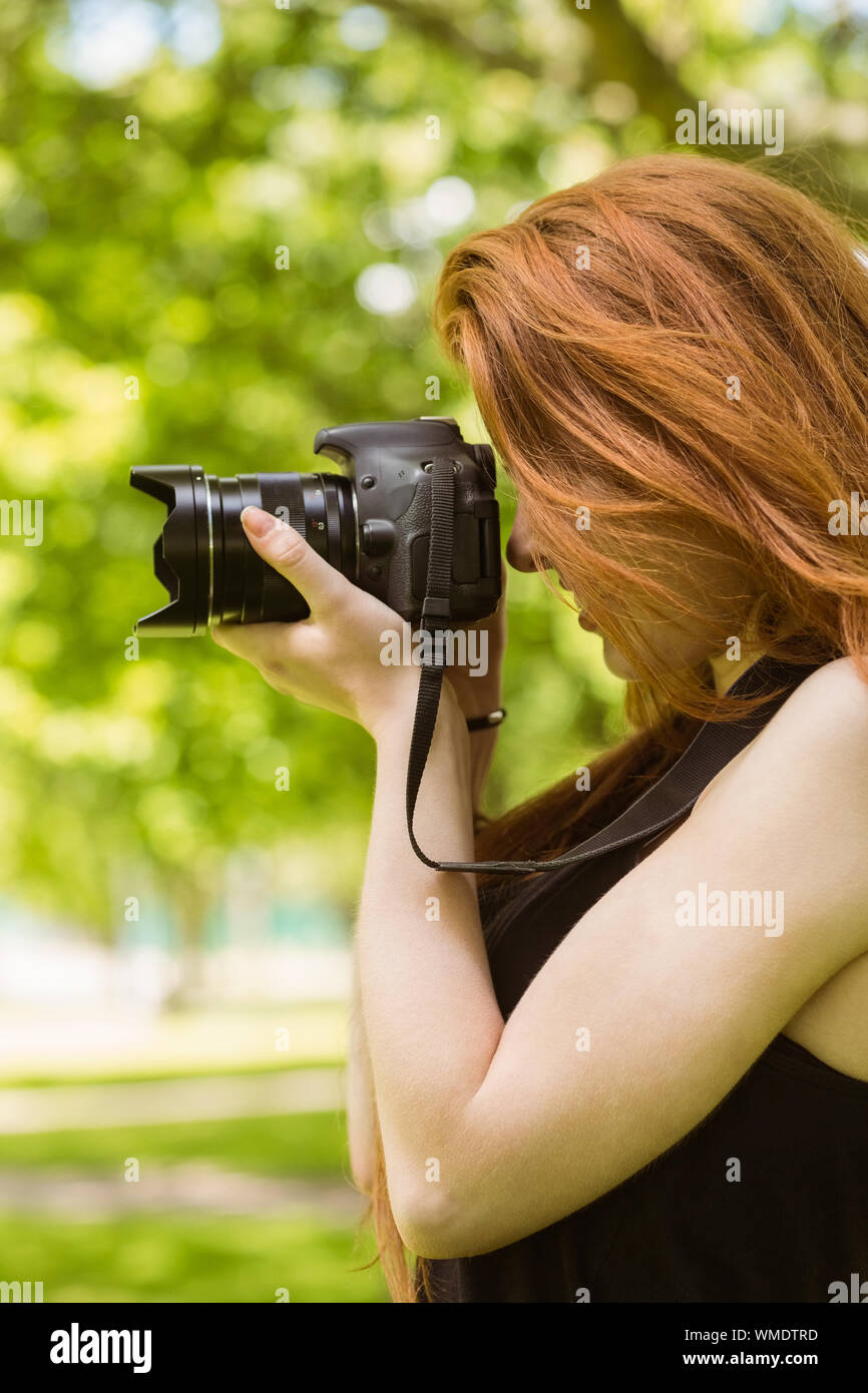 Side view of beautiful female photographer at the park Stock Photo - Alamy