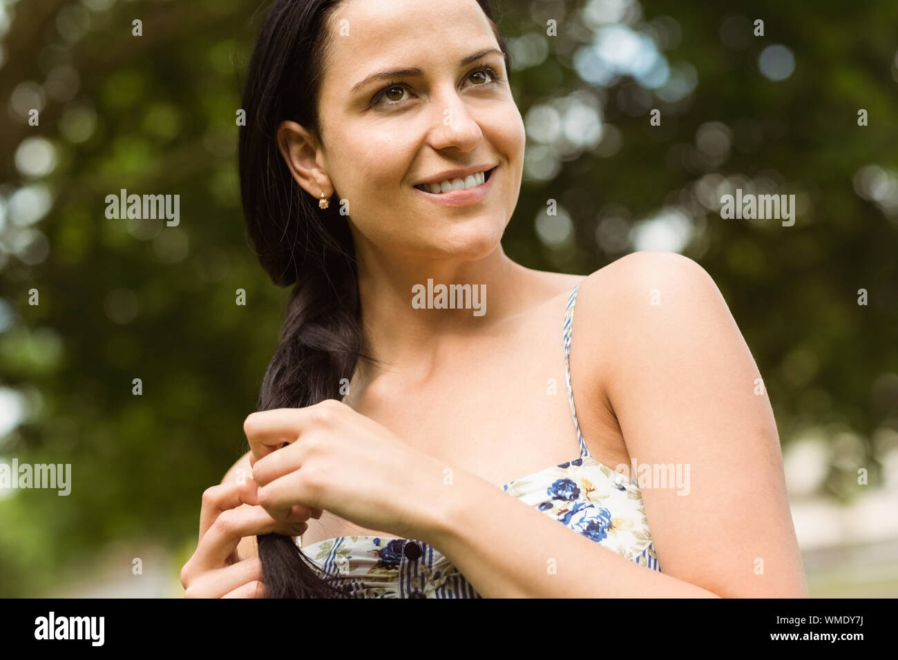 Portrait of a brunette in dress with braid in the park Stock Photo - Alamy