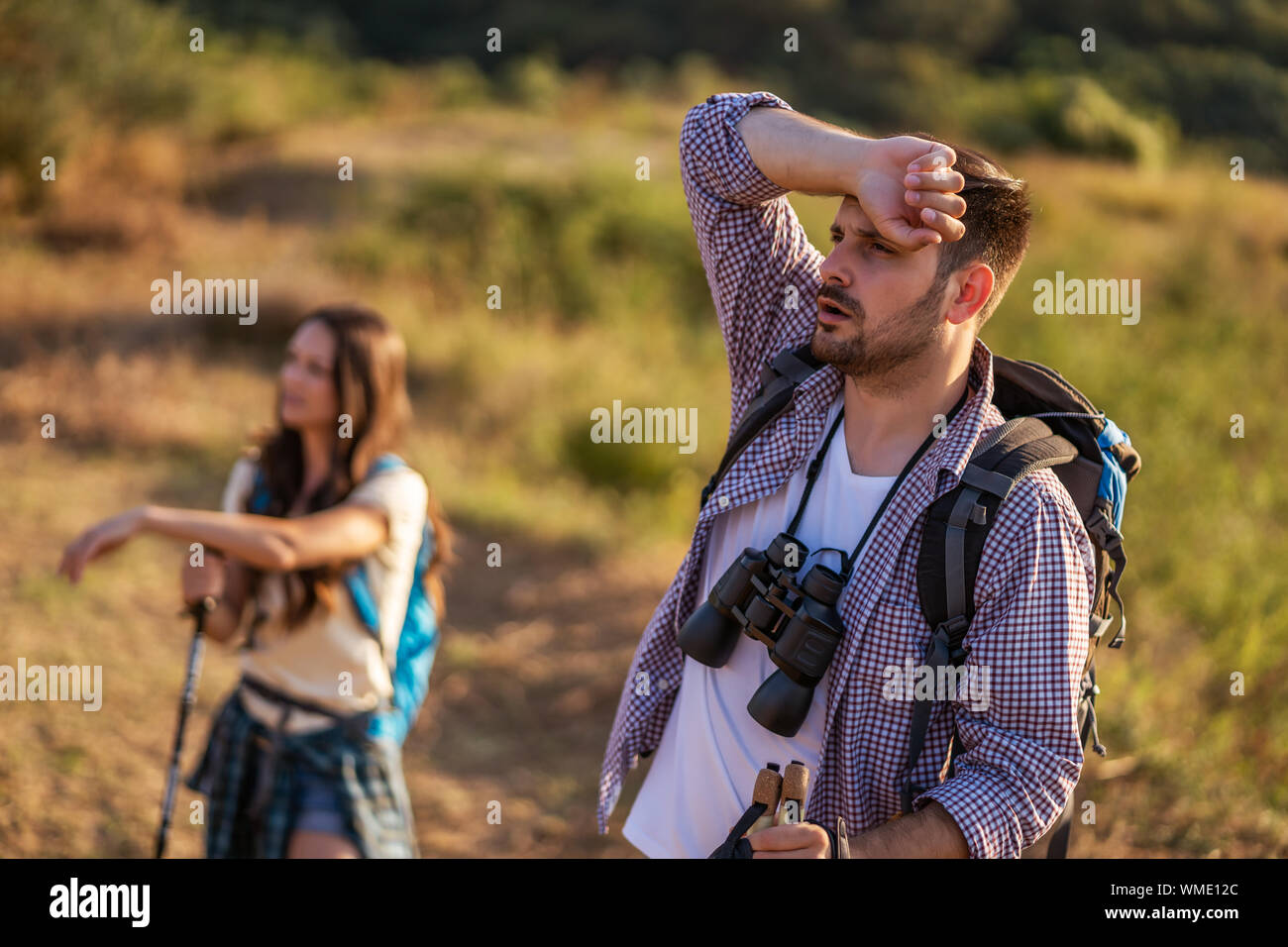 Couple is hiking in mountain. They are tired Stock Photo - Alamy