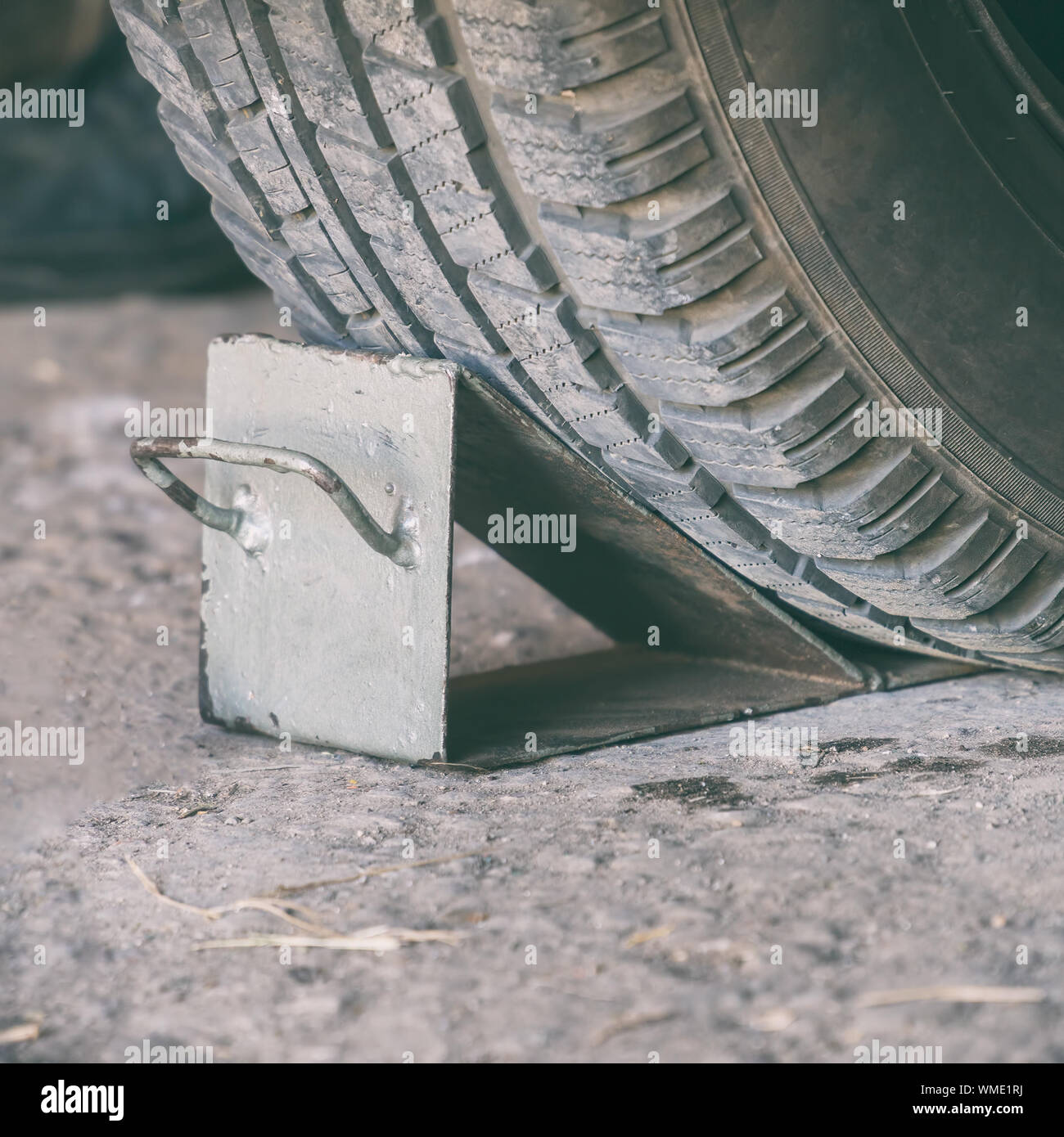 Metal wheel chock for a car wheel Stock Photo - Alamy