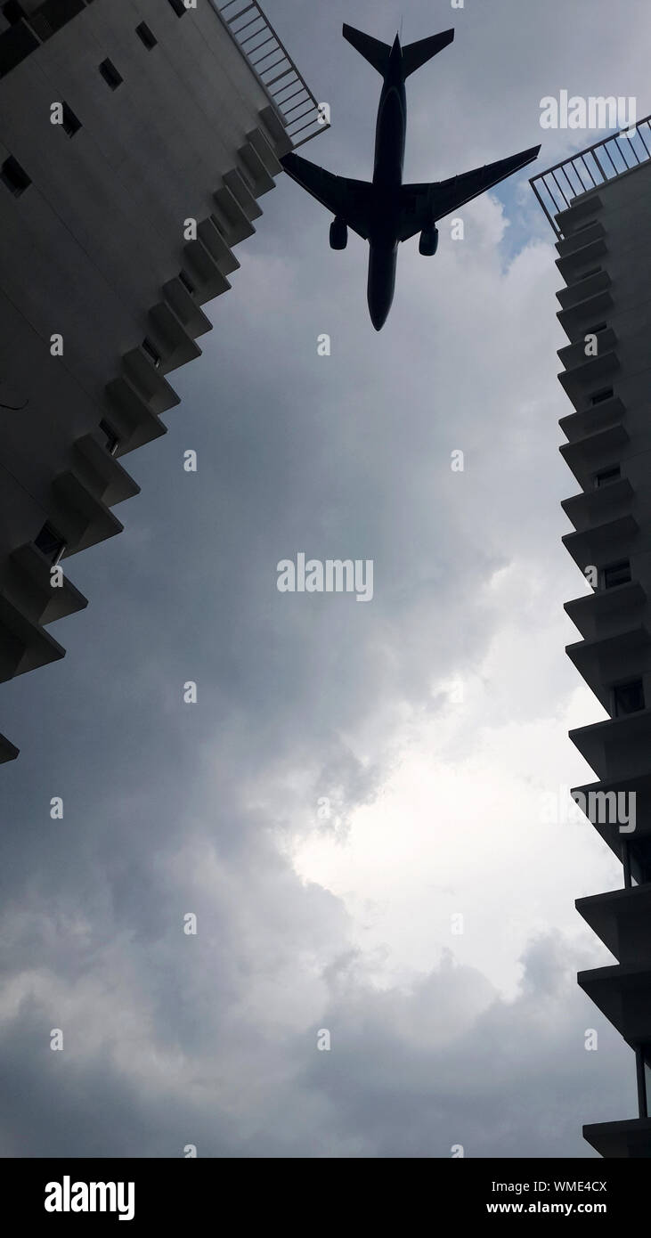 Airplane flying over buildings hi-res stock photography and images - Alamy