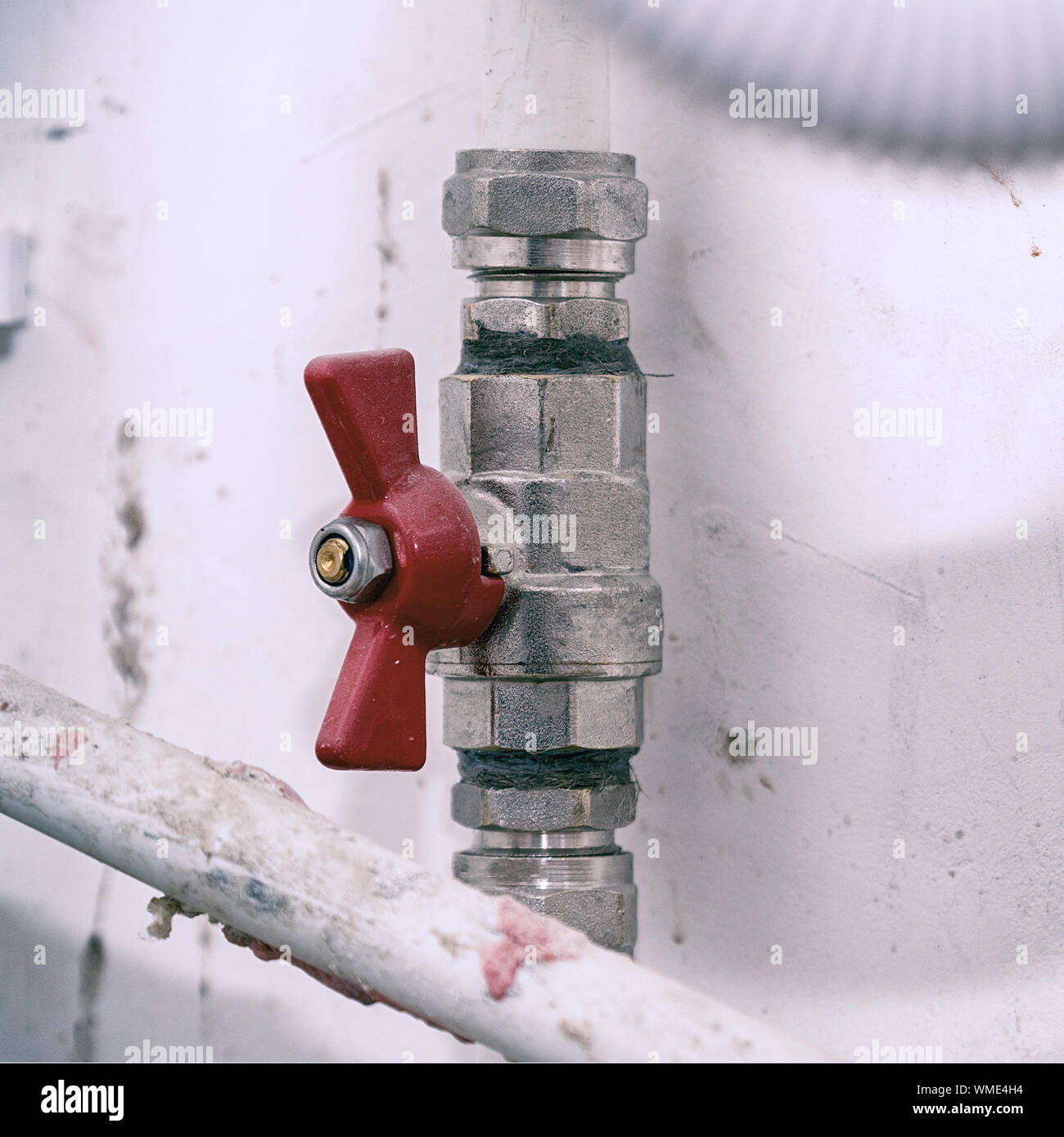 Tap with red handle on white plastic water pipe Stock Photo - Alamy