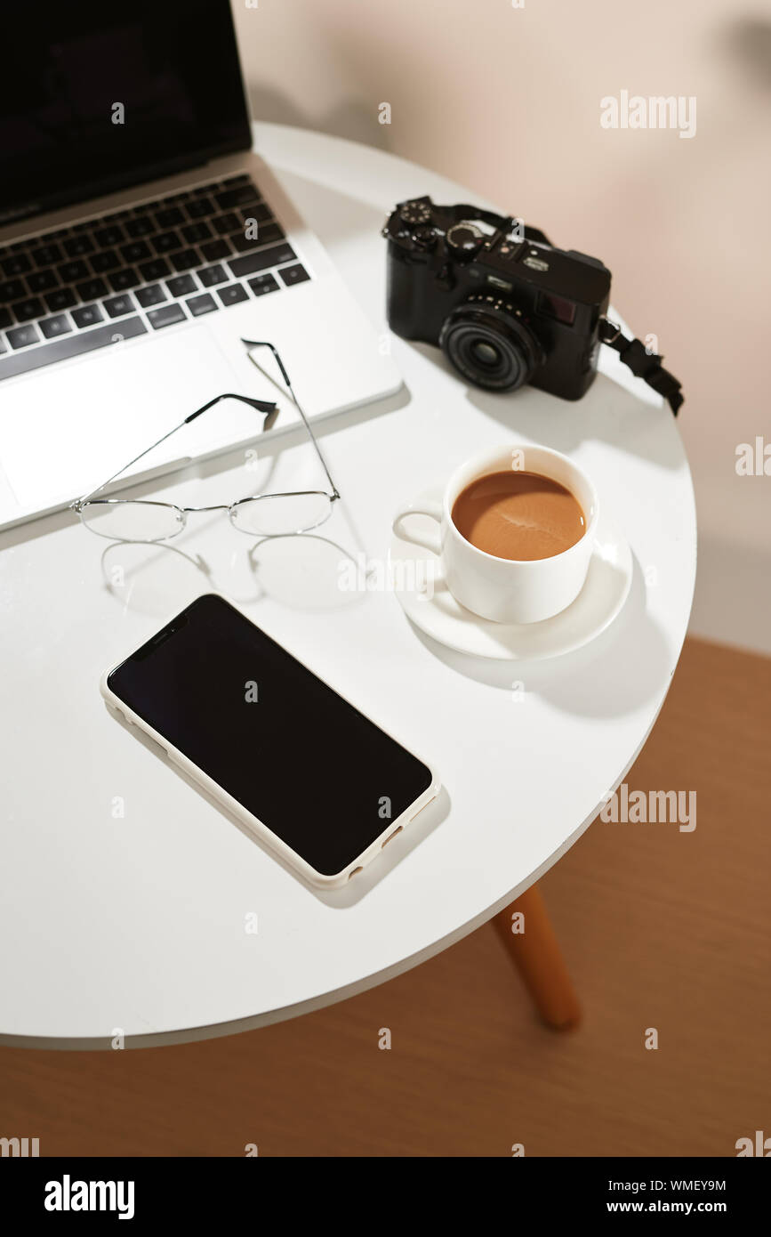 top view of office desk table with coffee cup, laptop, camera ...