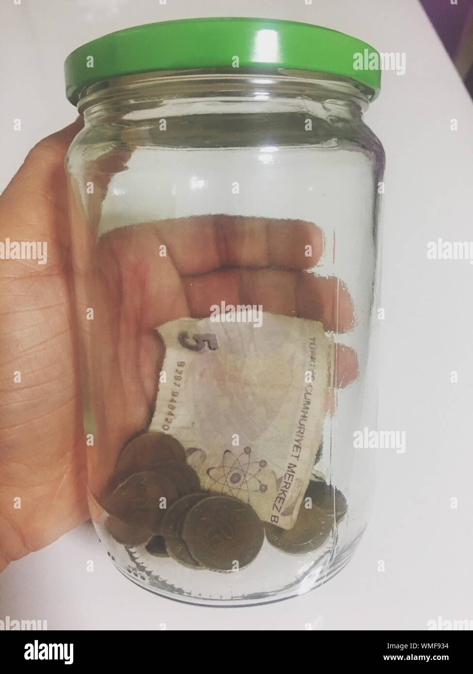 Money jar hand hi-res stock photography and images - Alamy