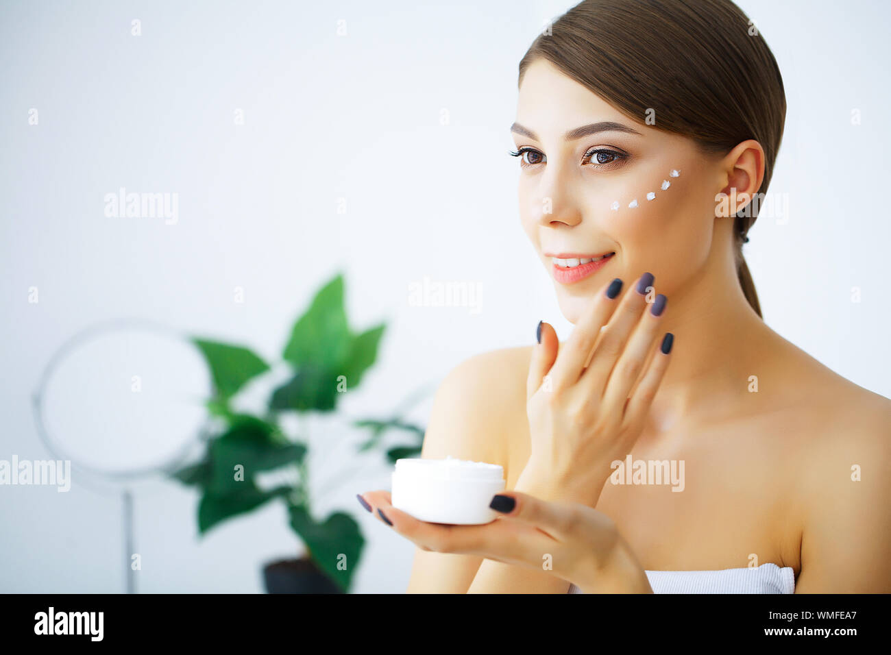 Beauty and Care. Happy Smiling Young Woman Holds Cream for Face. Girl ...