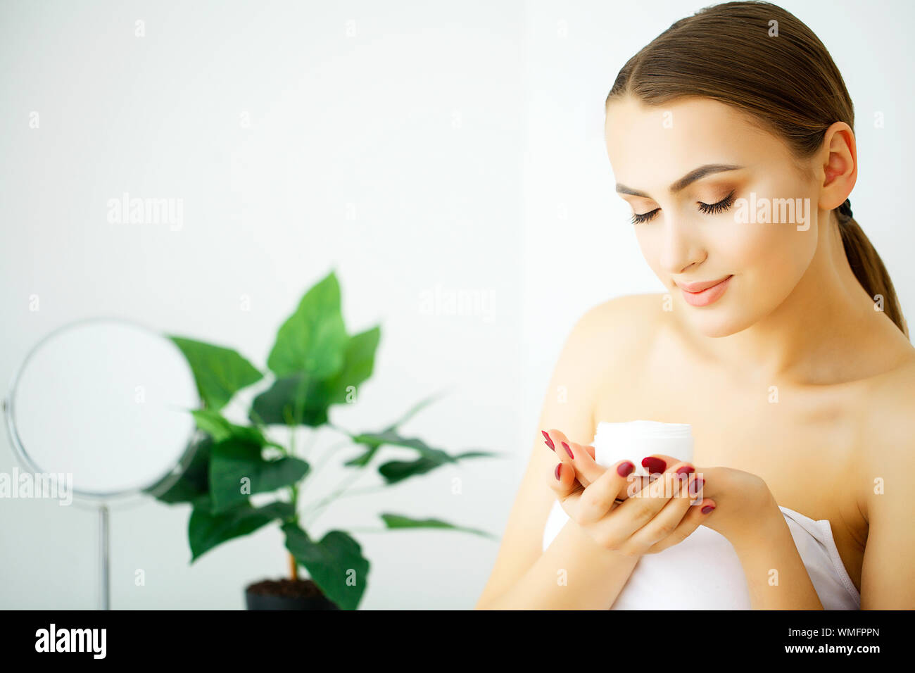 Beautiful model applying cosmetic cream treatmen on her face Stock ...