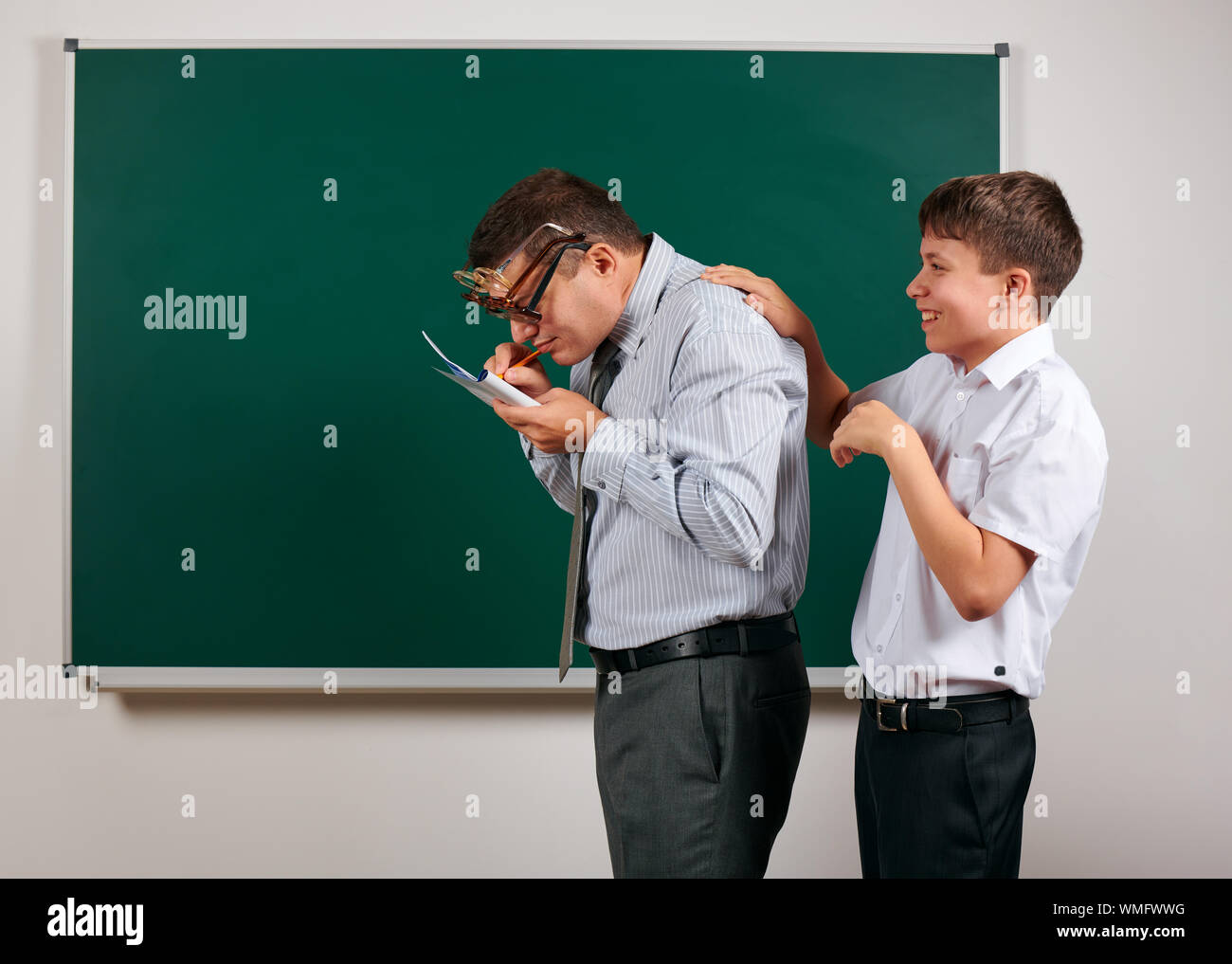 Portrait of a teacher checking homework, reading school exercise books ...