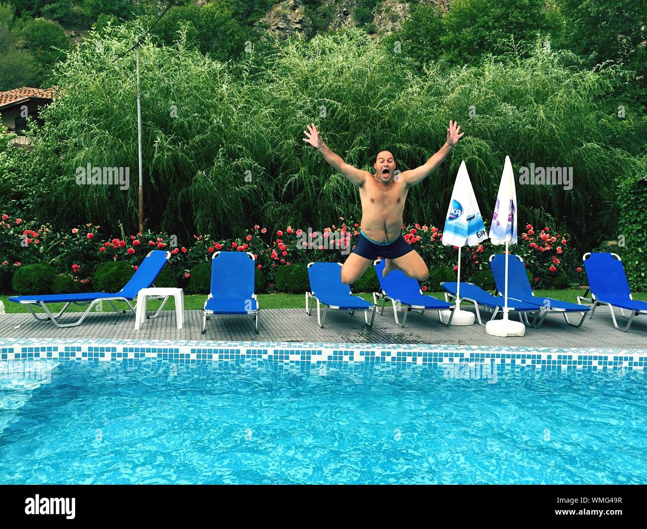 Excited Young Man Jumping In Swimming Pool Stock Photo - Alamy