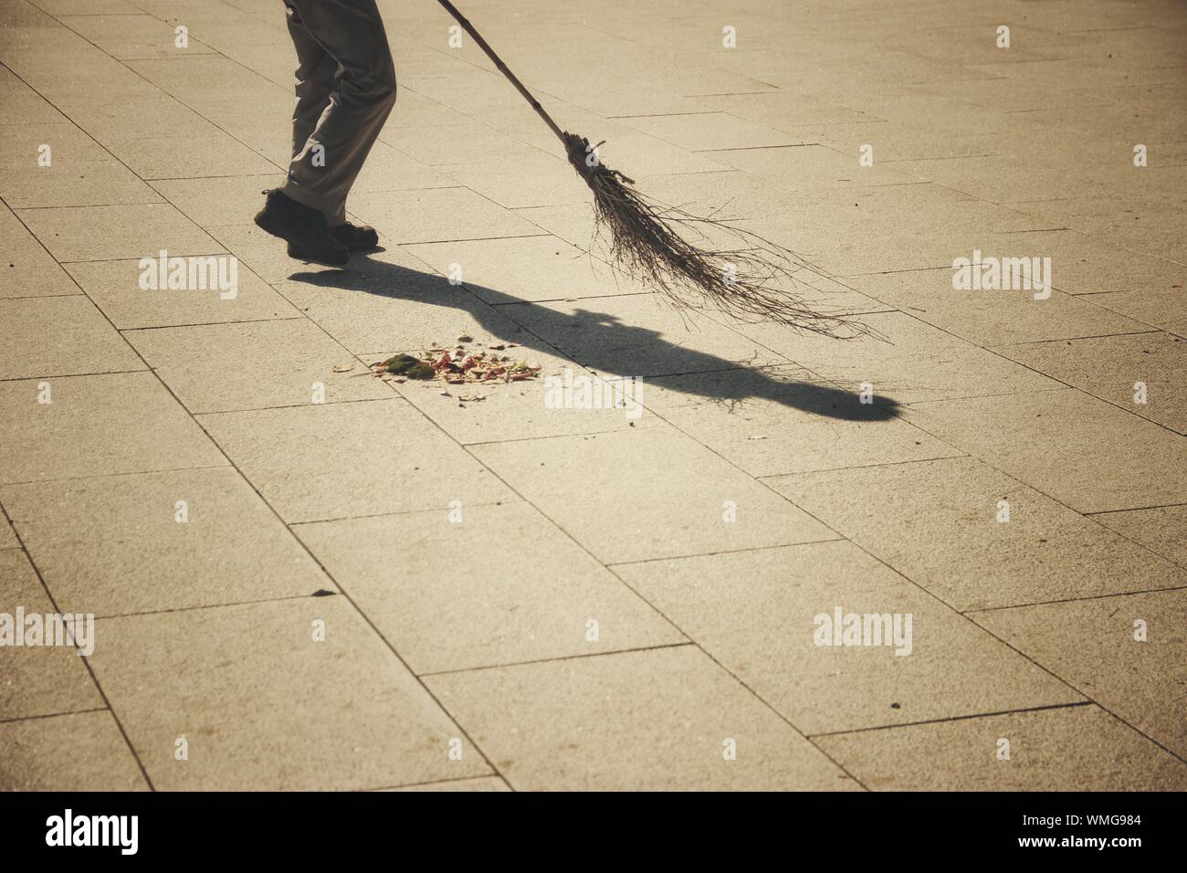 Low Section Of Person Sweeping Floor Stock Photo - Alamy
