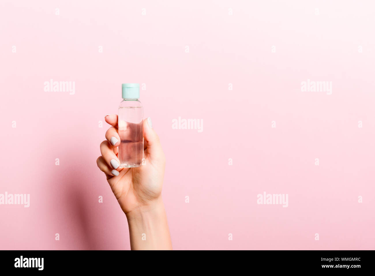 Female hand holding cream bottle of lotion isolated. Girl give tube ...