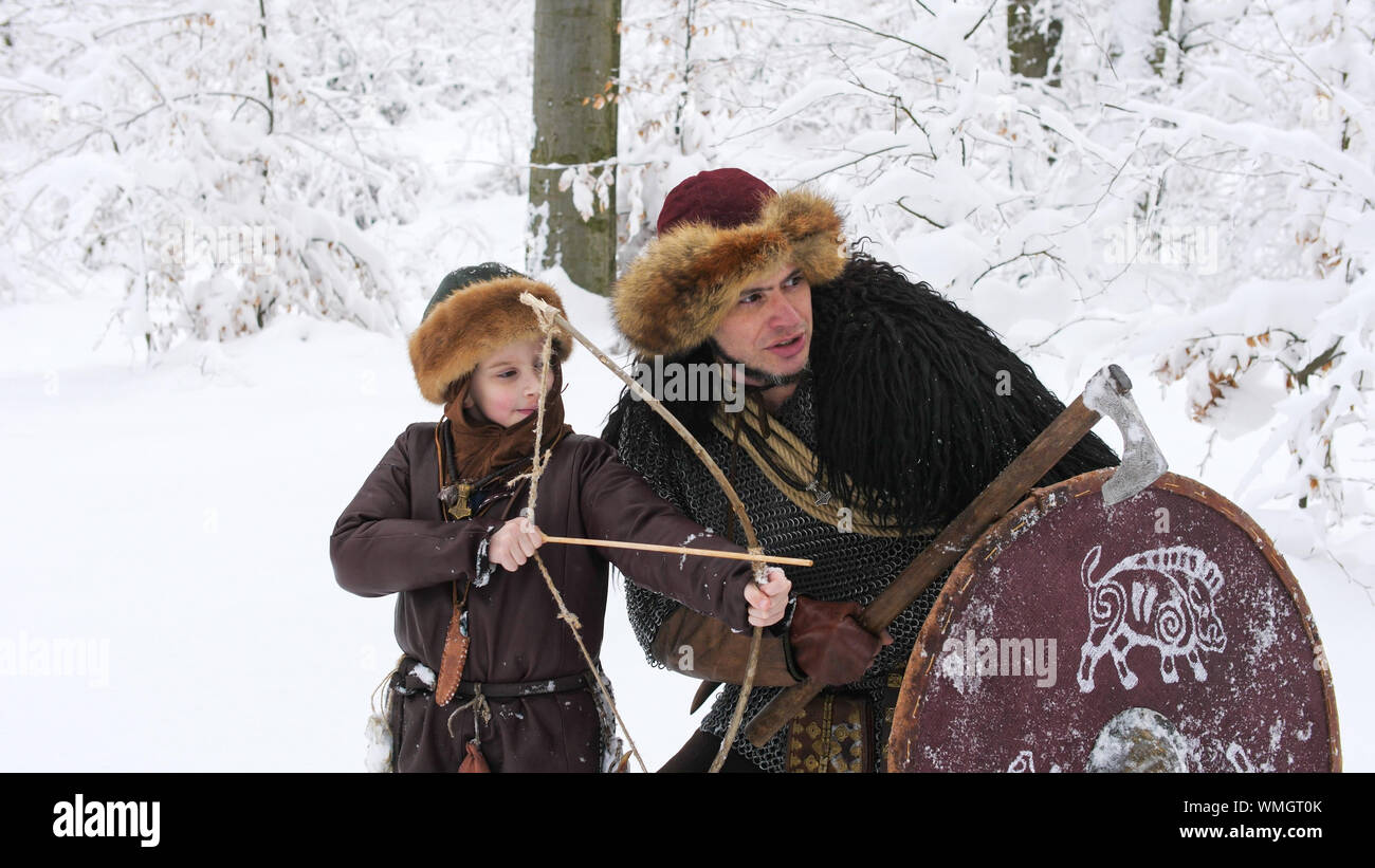 Father viking teach his son to archery in the winter forest Stock Photo ...