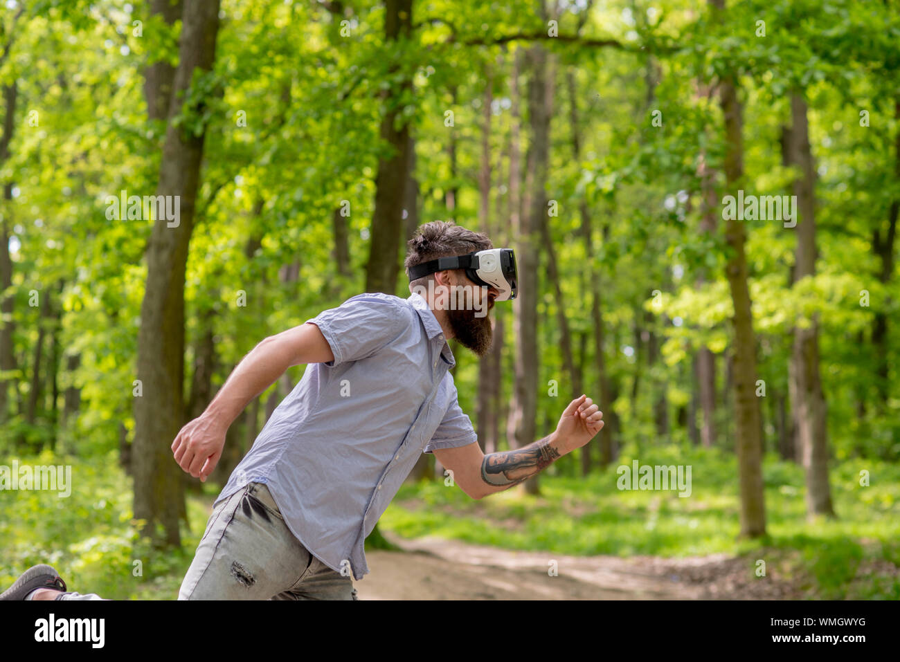 Bearded man having 3D experience wearing VR headset. Side view hipster ...