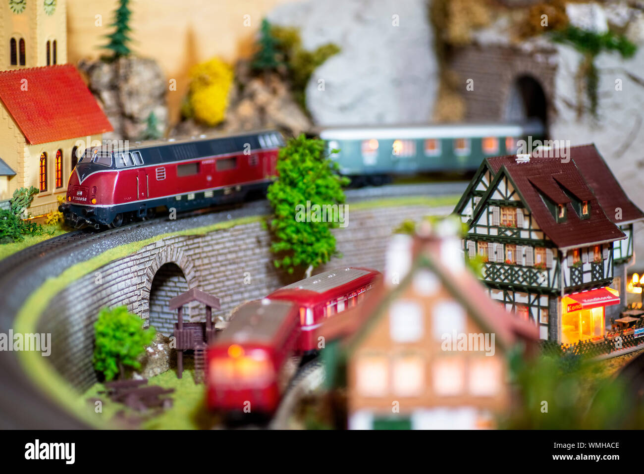 Passenger train with diesel locomotive and rail bus on a model railway ...