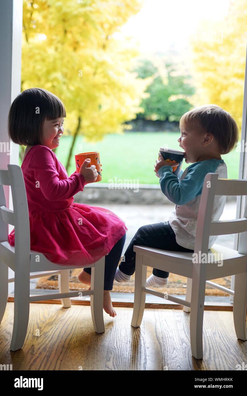 Two girls sitting on chairs hi-res stock photography and images - Alamy