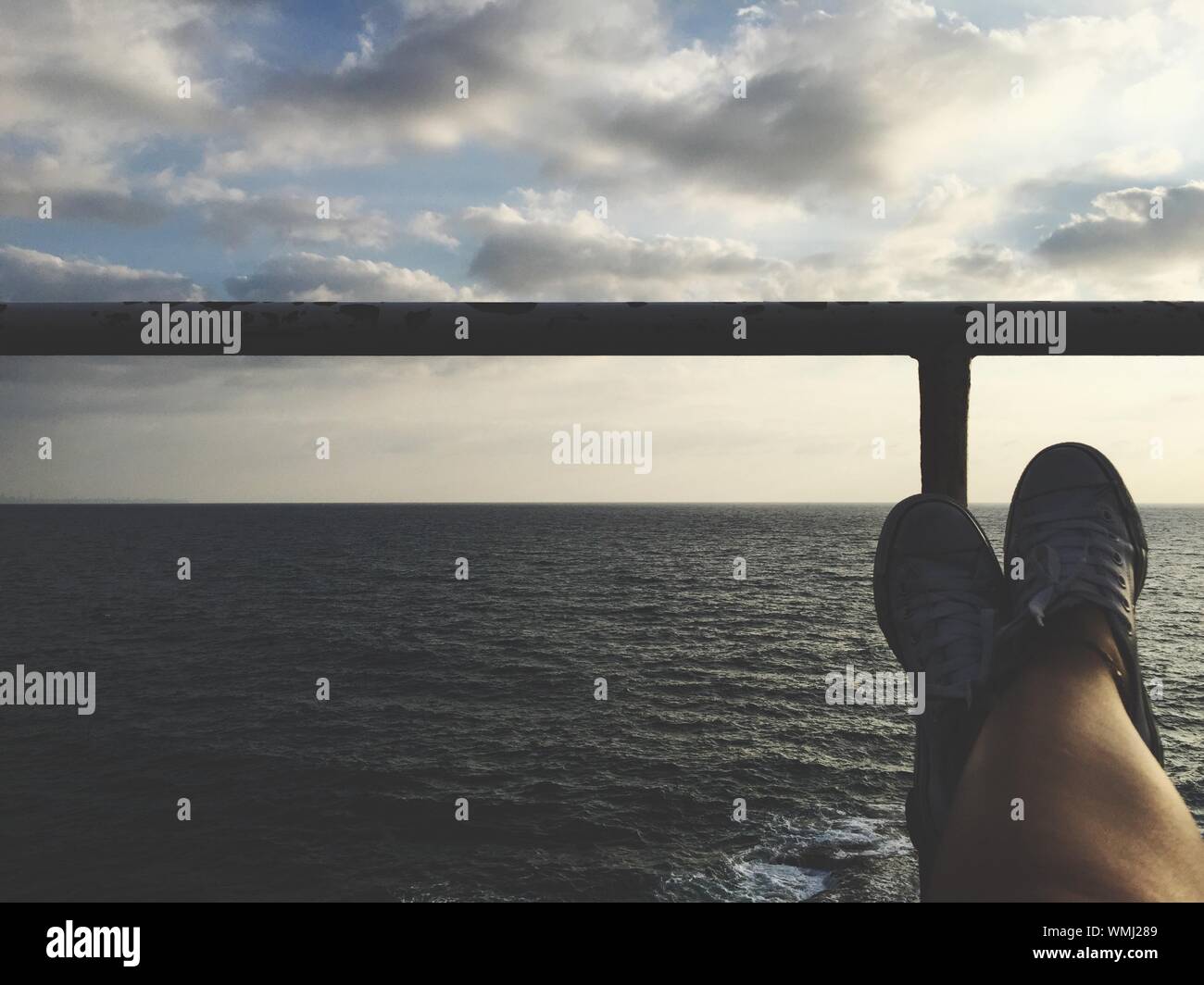 Feet up on railing hi-res stock photography and images - Alamy