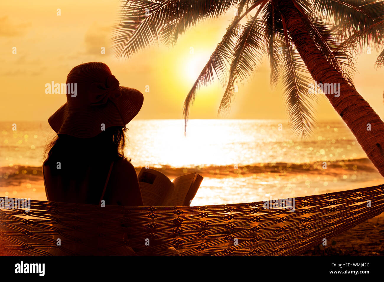 Person reading book on the beach at sunset hi-res stock photography and ...