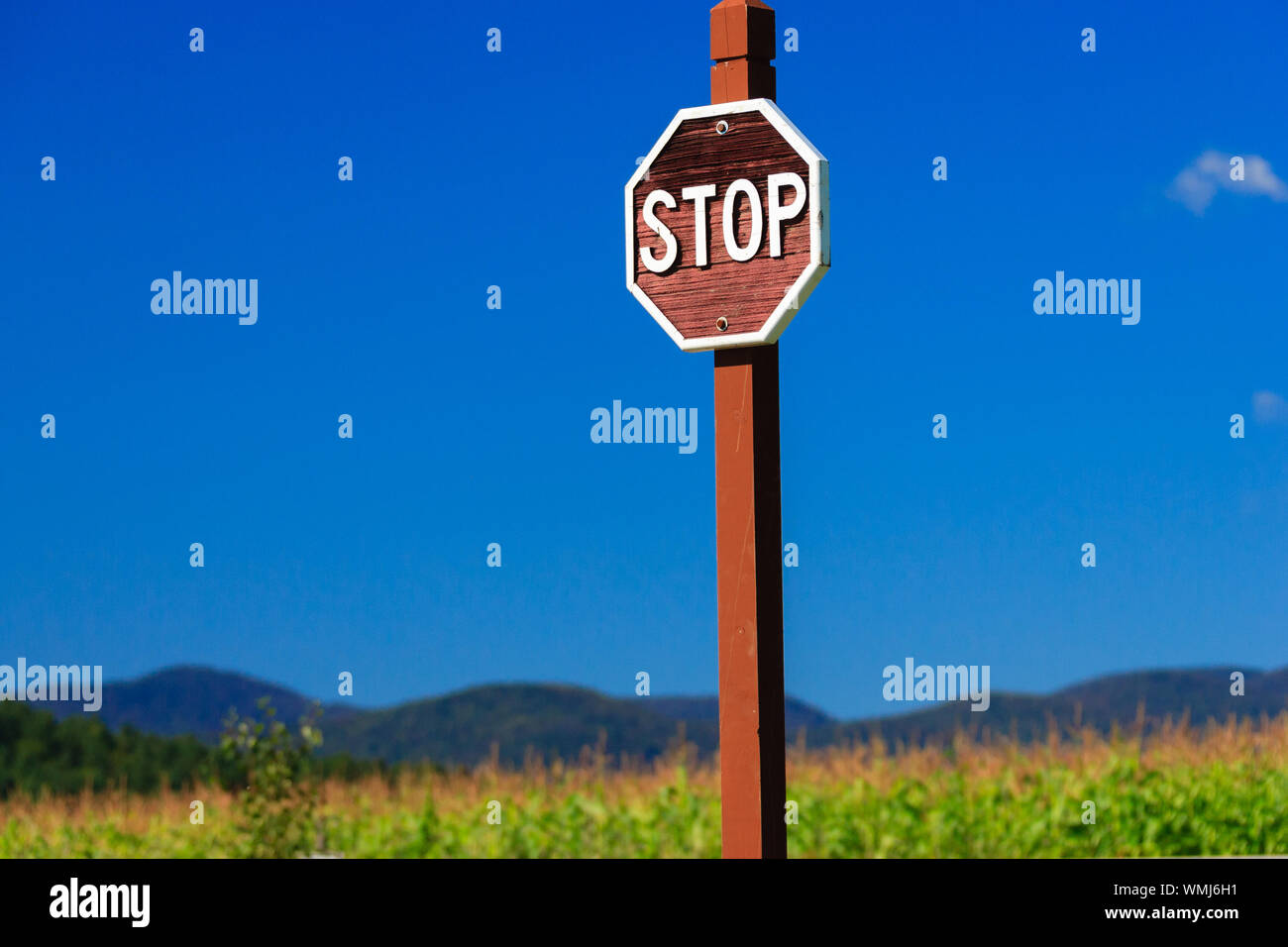 Old fashioned wooden stop sign against a blue sky, Stowe Vermont, USA ...