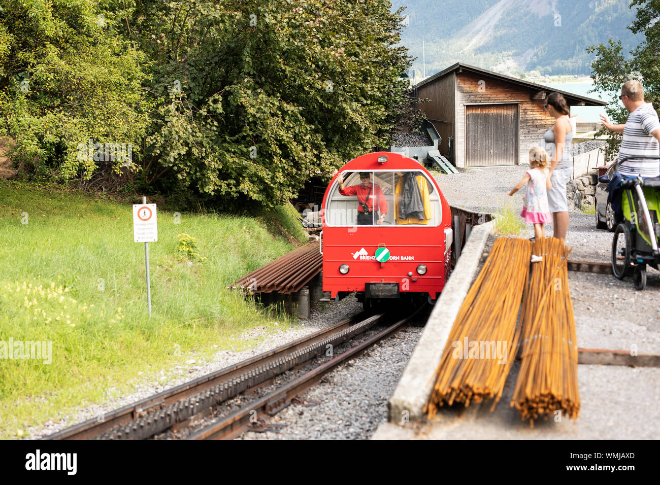 A family waves to the engineer of the Brienz Rothorn Railway steam ...