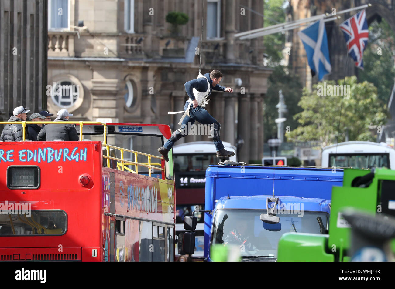 A stuntman jumps from an open-top bus onto a van on Waterloo Place in ...